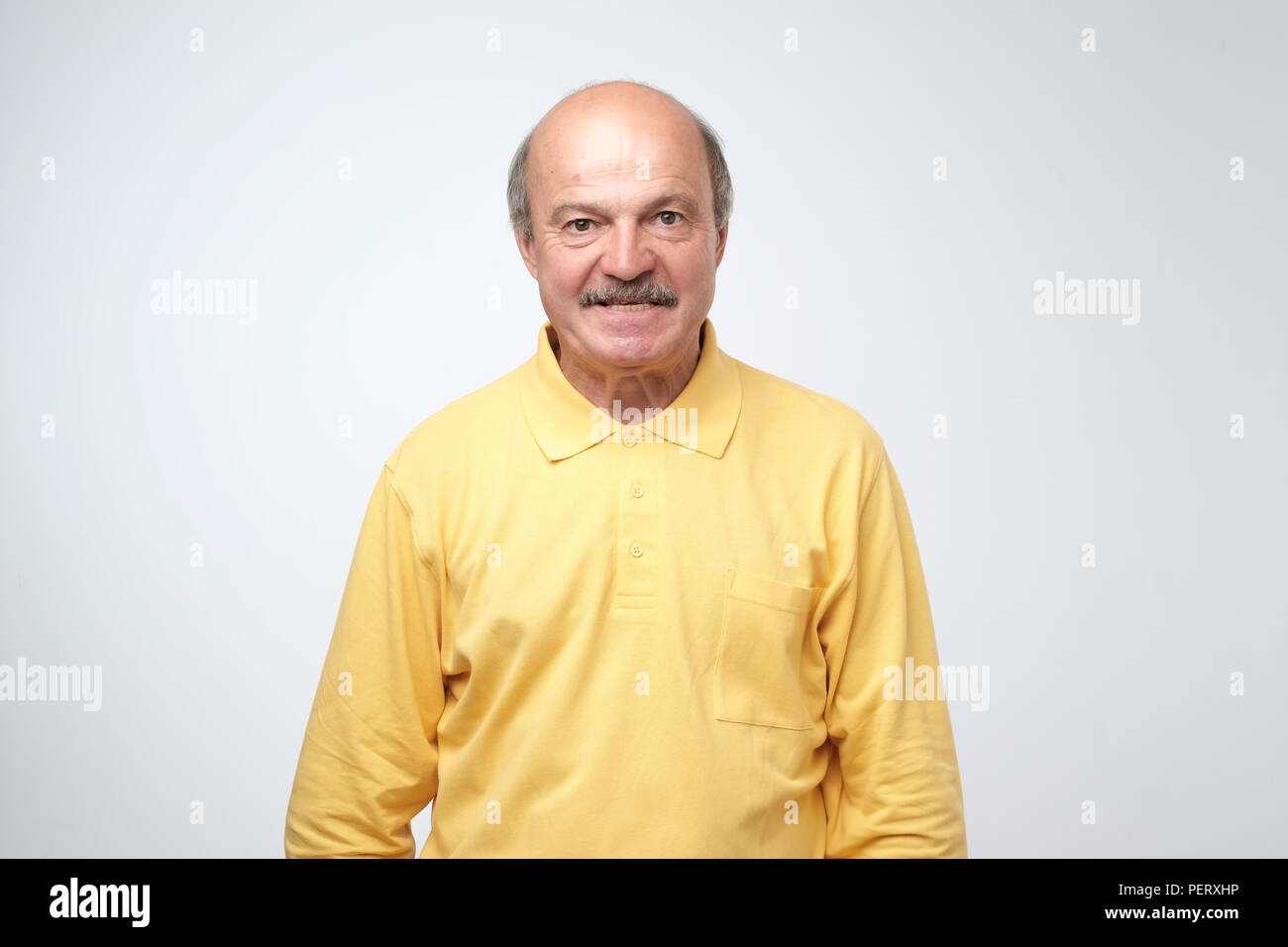 Very angry aggressive european man portrait in yellow t-shirt. He is ...
