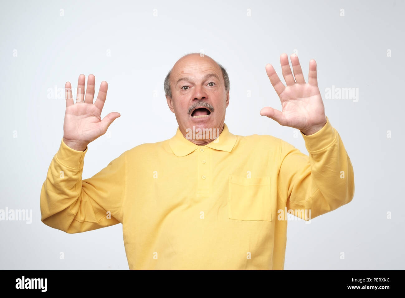 I'm afraid. Portrait of senior scared man in yellow pulover. . Male ...