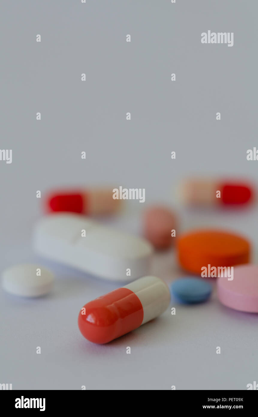 Many different colors pills and tablets isolated on white background ...