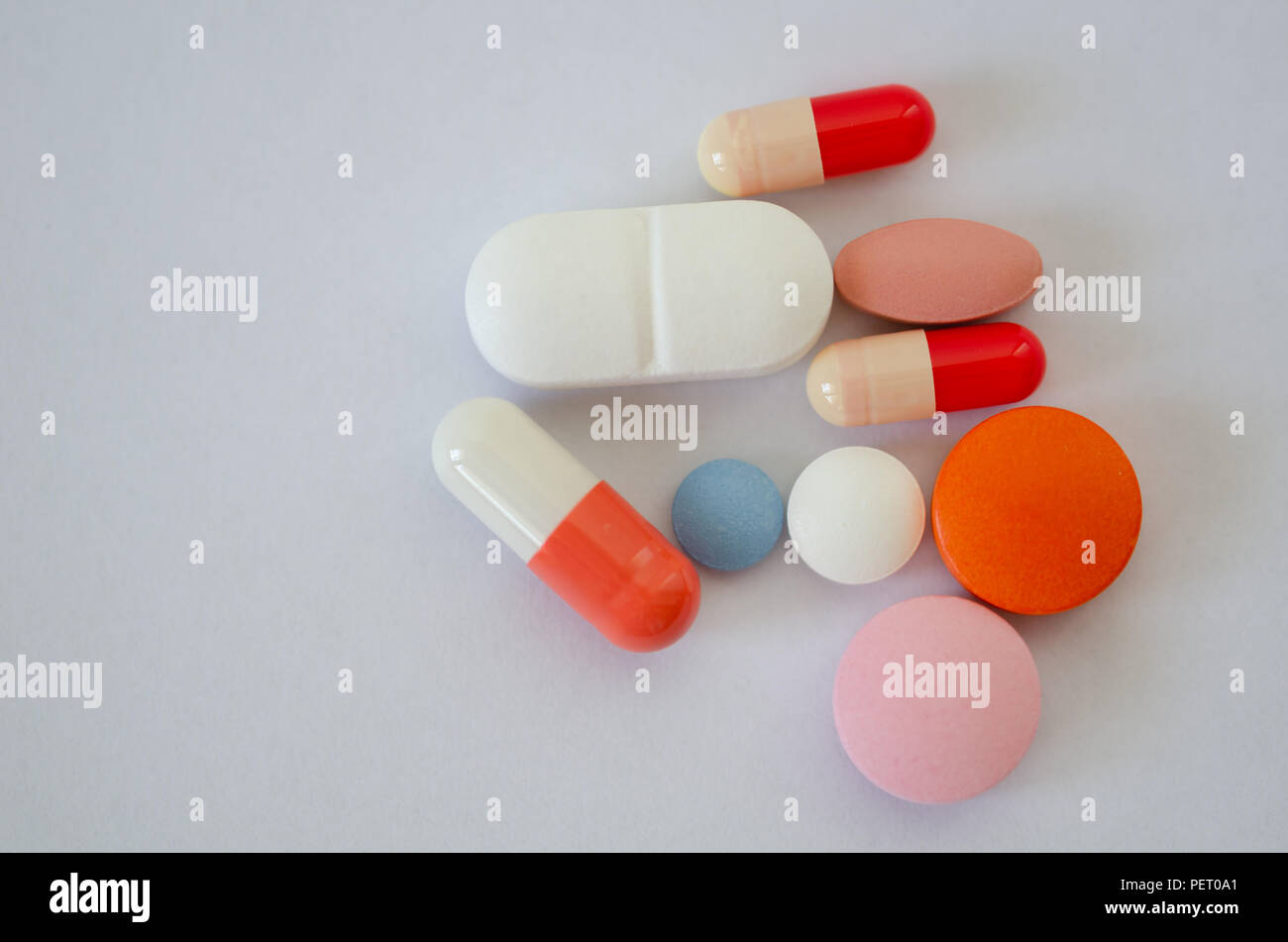 Many different colors pills and tablets isolated on white background ...
