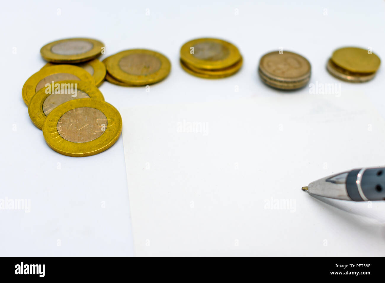 financial planning with coins and a pen isolated on a white background ...