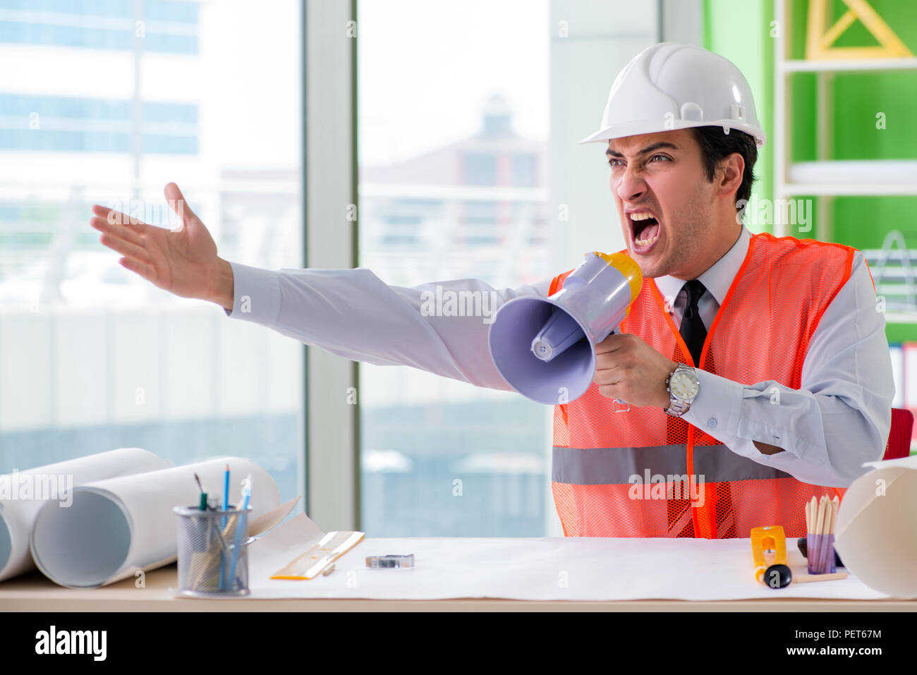 Construction supervisor with loudspeaker sitting in the office Stock ...
