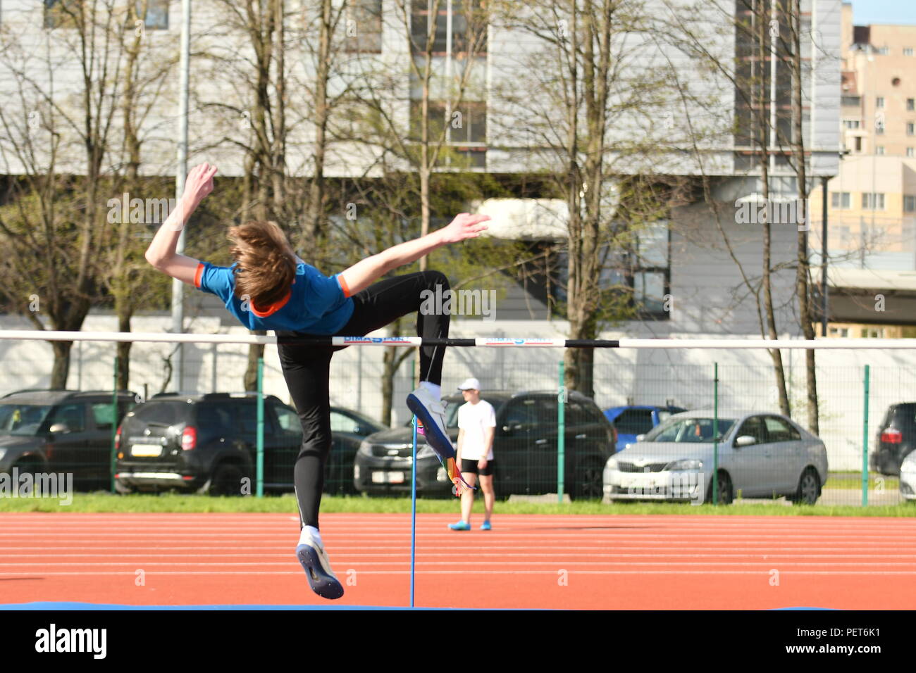 Young athlete performs high jump attempt in local contest Stock Photo ...