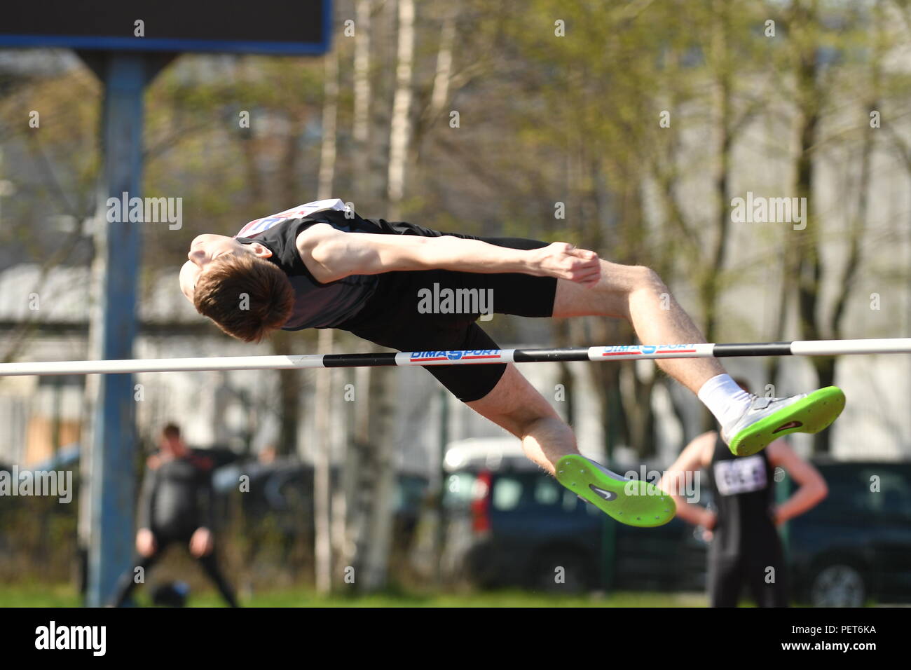 Young athlete performs high jump attempt in local contest Stock Photo ...