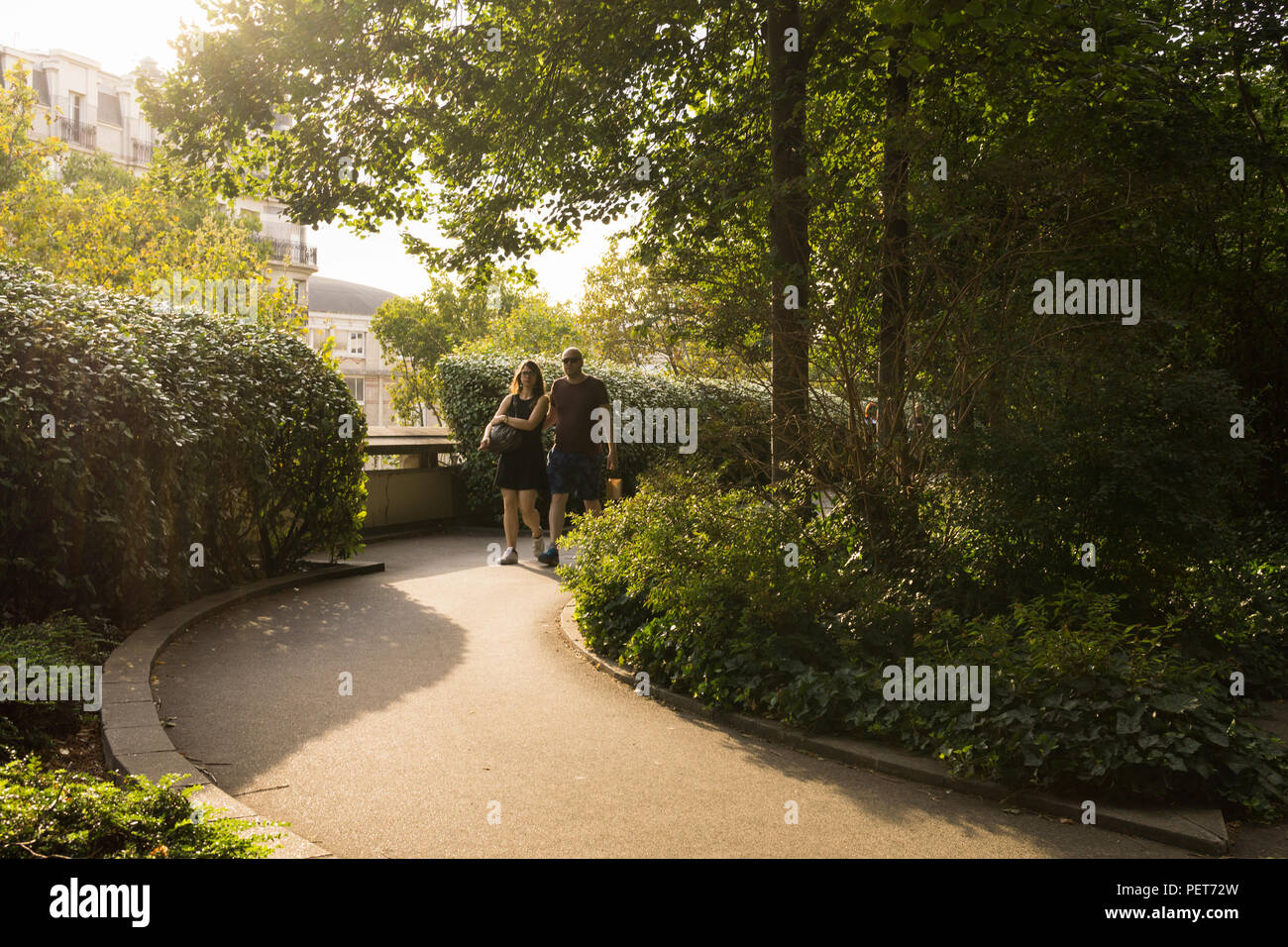 Paris greenery and urban garden - Man and woman strolling along the ...