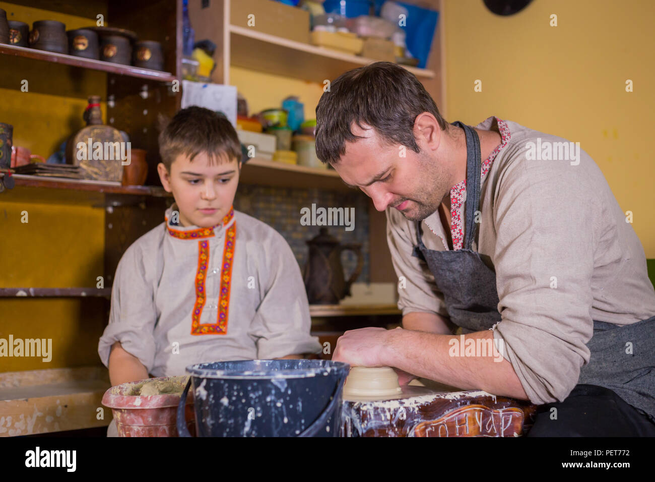 Pottery class and workshop: professional male potter working with boy ...
