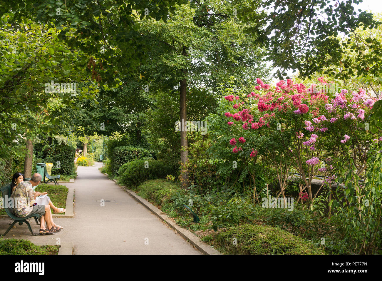 Paris greenery and urban garden - Man and woman sitting on bench at the ...