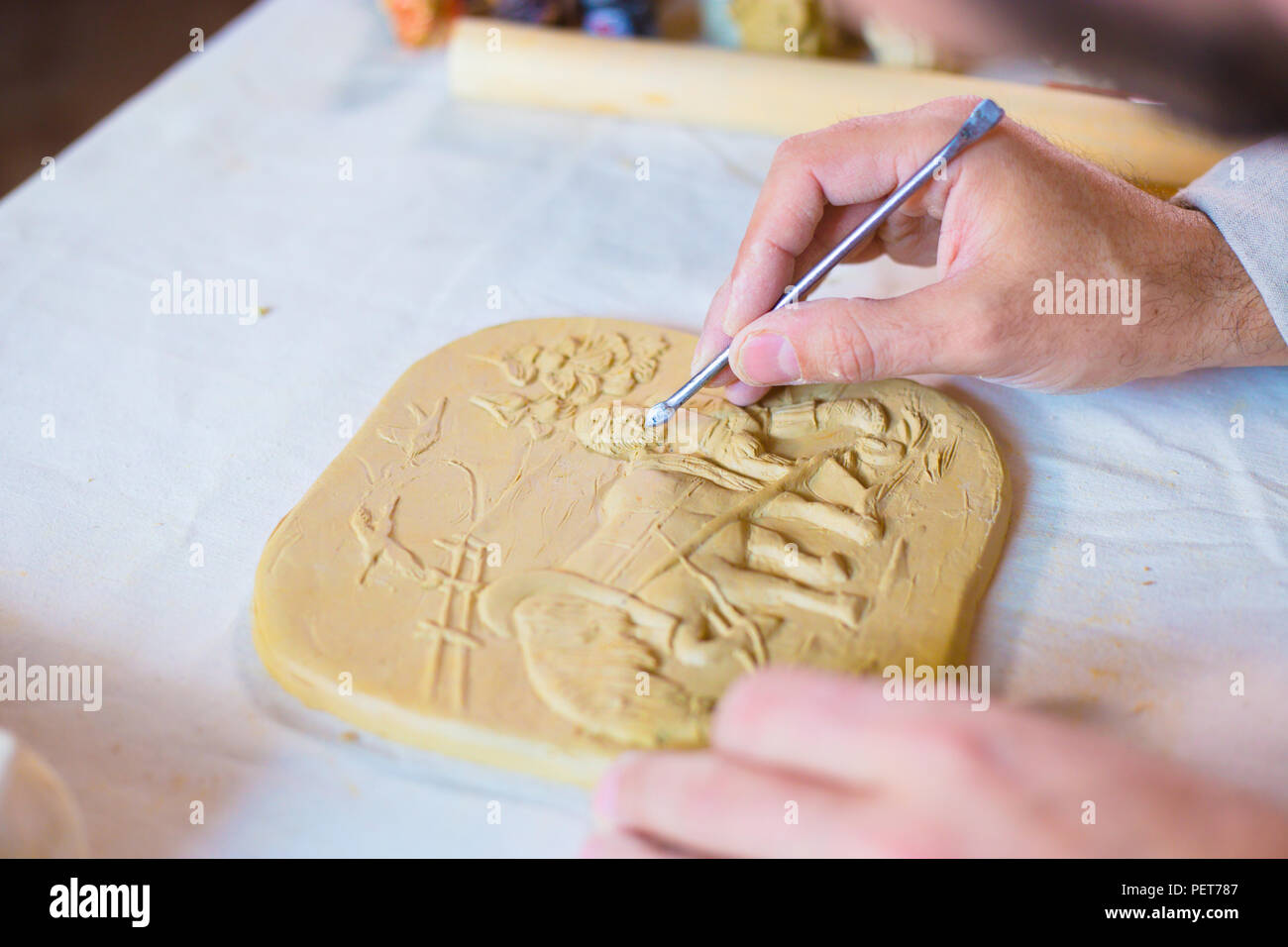 Professional male potter making clay stamp picture. Handwork, crafting ...