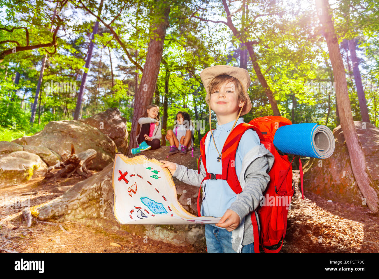Summer camp game boy with treasure map and other kids in the forest ...