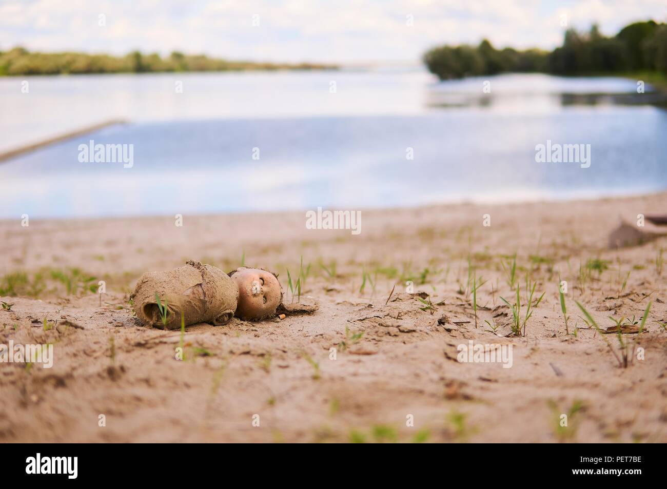 Doll on sand near river Stock Photo - Alamy