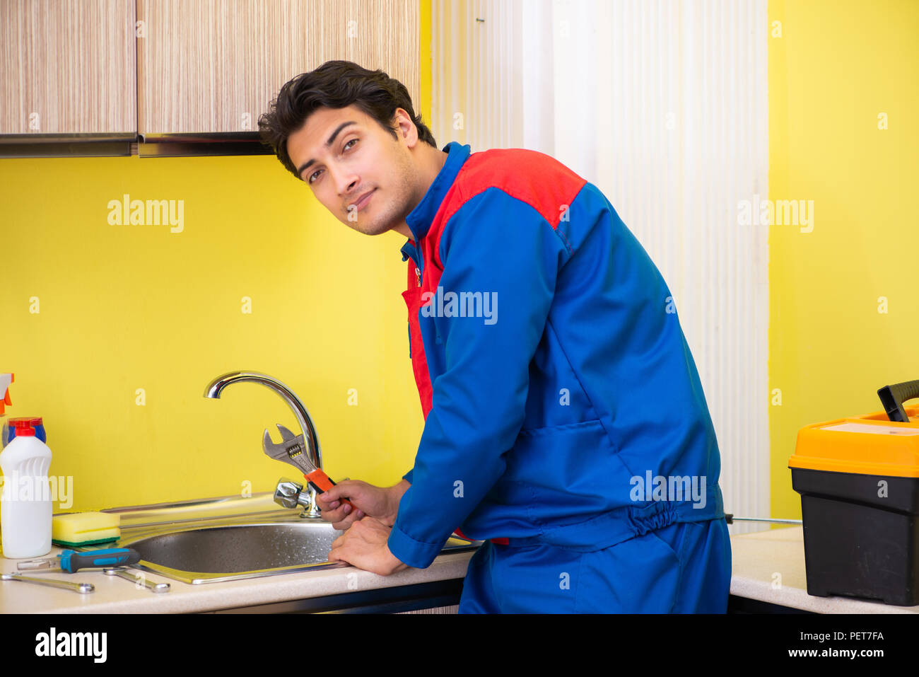 Plumber repairing tap at kitchen Stock Photo - Alamy