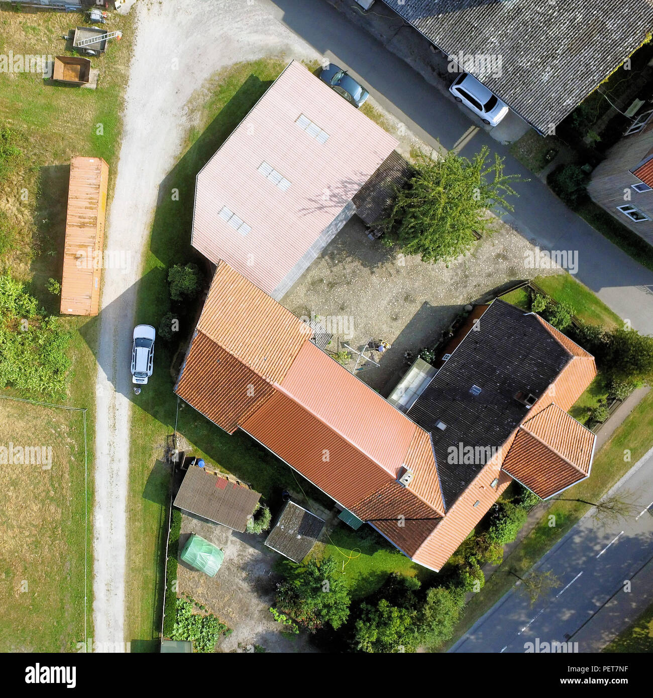 Aerial view of a barn, a house, a street and a lawn with a vertical ...