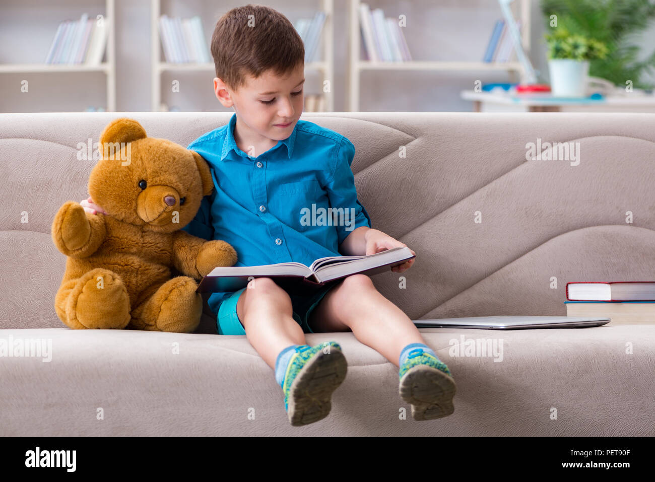 Small boy reading books at home Stock Photo - Alamy