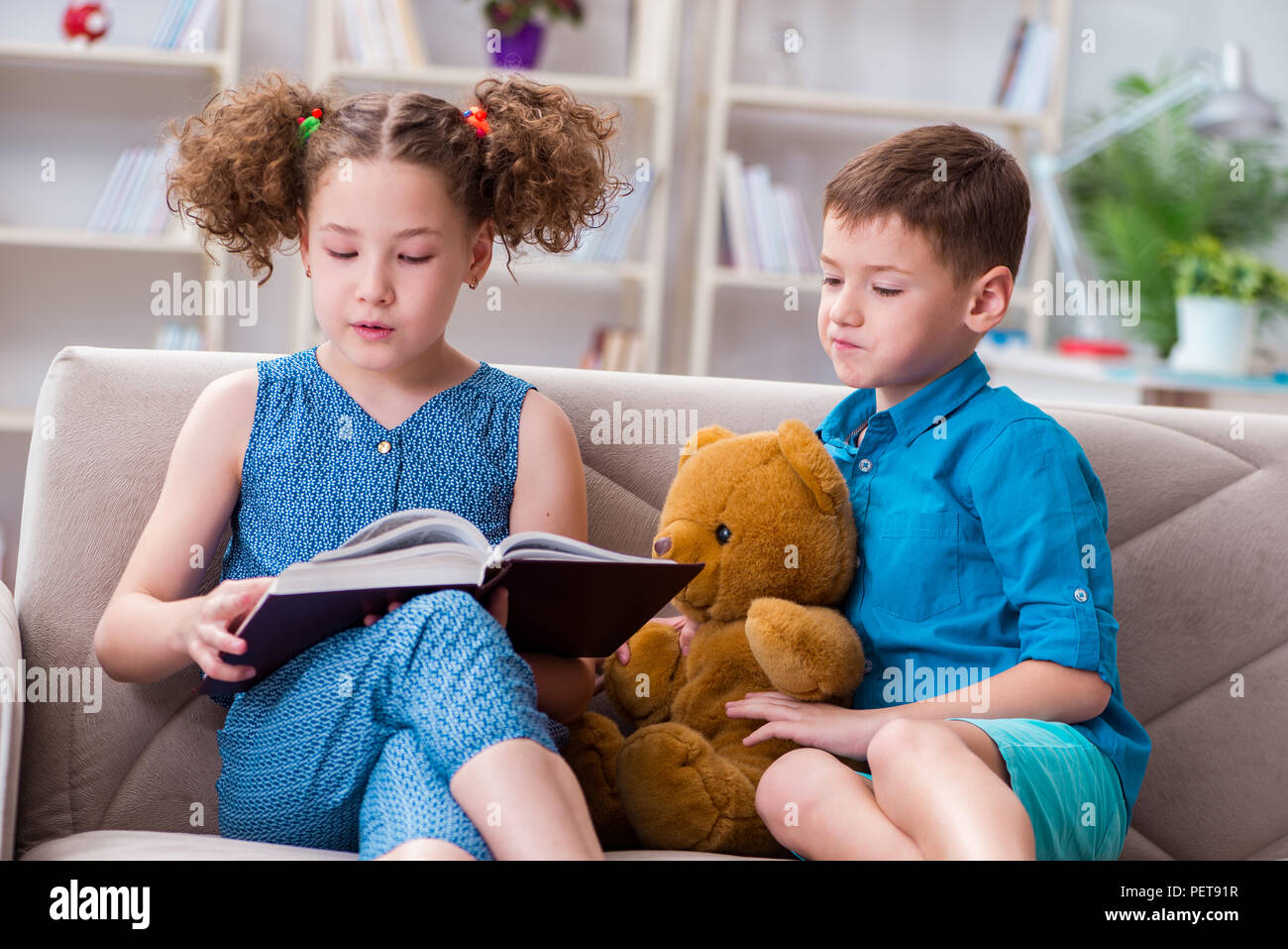 Two kids reading books at home Stock Photo - Alamy