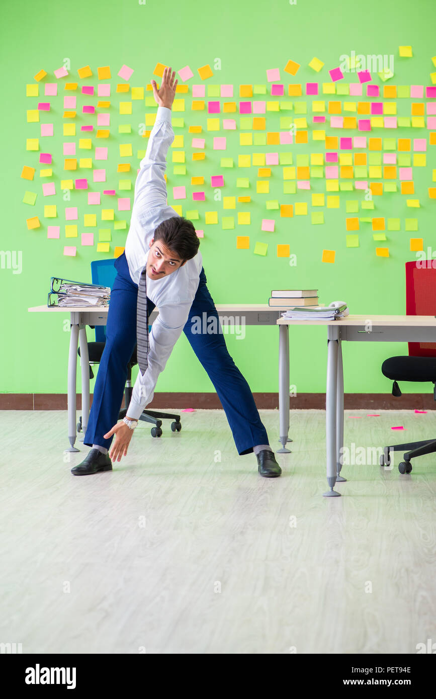 Man in the office with many conflicting priorities doing exercises ...