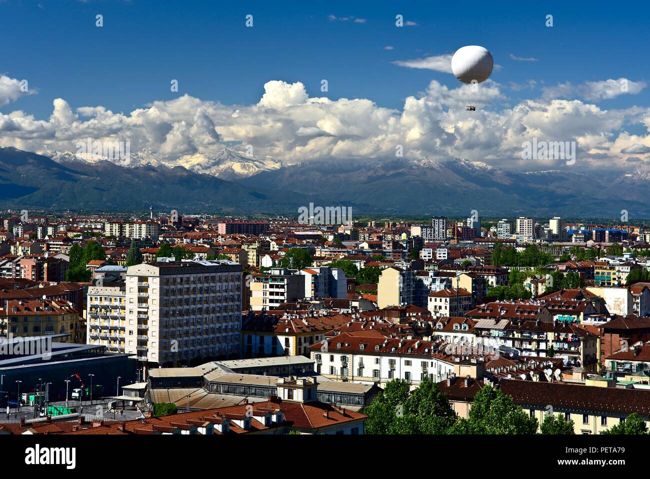 Bright white balloon gliding over Torino with picturesque mountains in ...