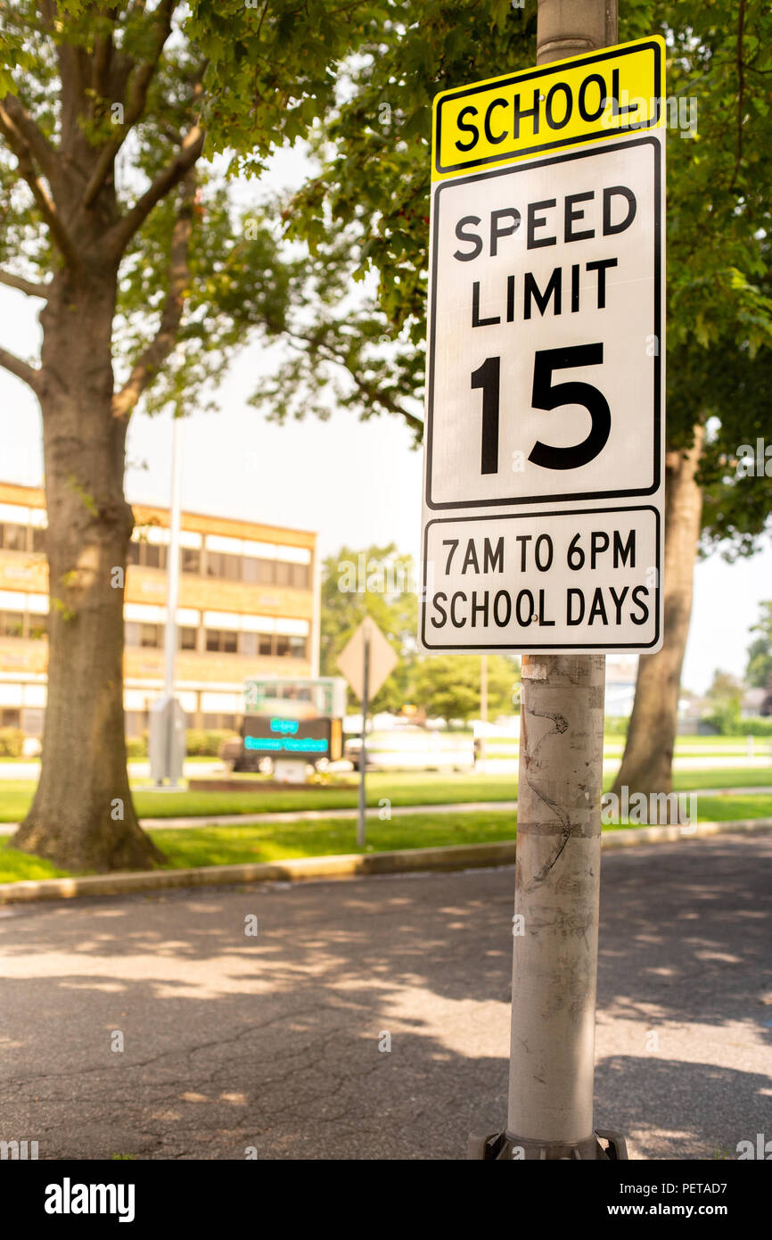 Sign indicating school zone speed limit of 15 miles per hour with ...