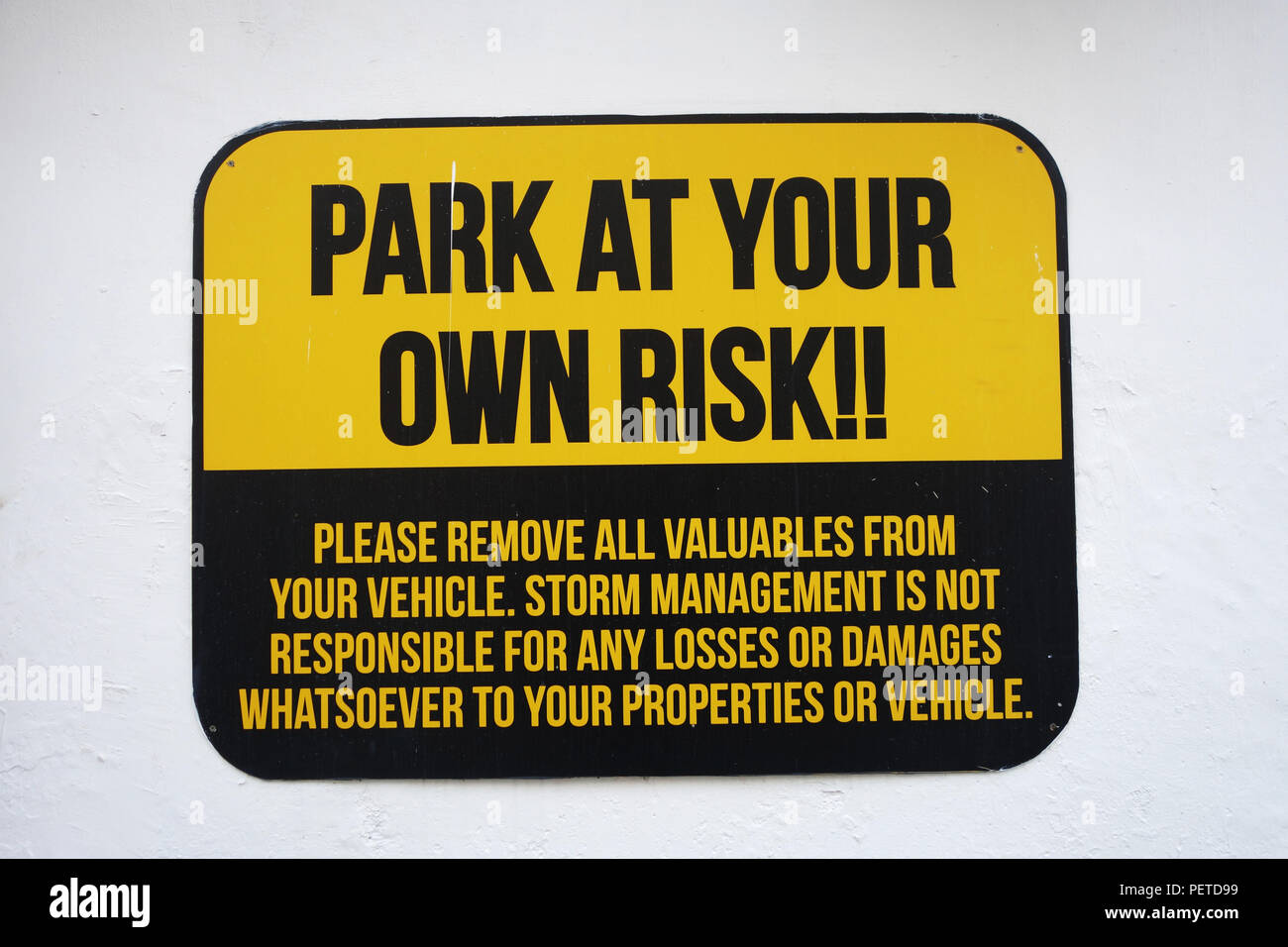 Park at your own risk sign on wall Stock Photo - Alamy