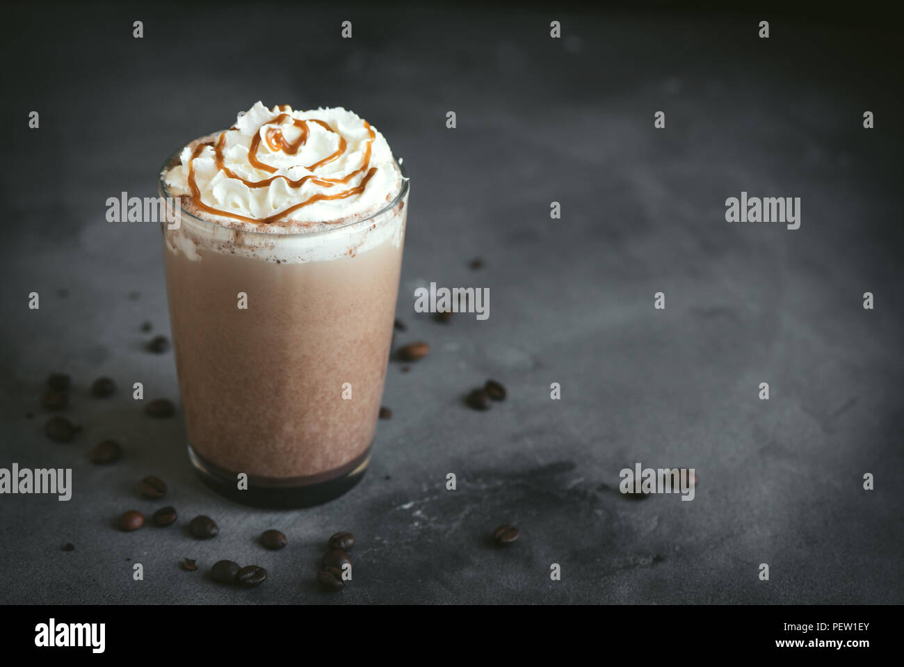 Cold Frappe Coffee (frappuccino) with whipped cream and caramel on dark ...