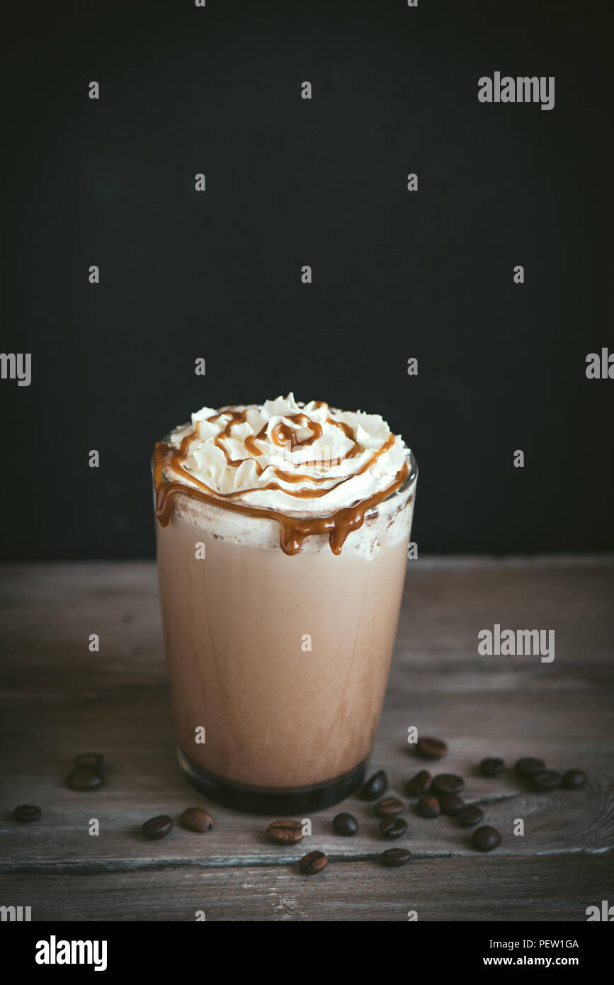 Cold Frappe Coffee (frappuccino) with whipped cream and caramel on dark ...