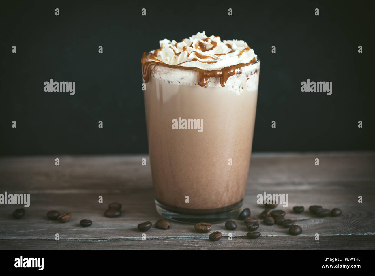 Cold Frappe Coffee (frappuccino) with whipped cream and caramel on dark ...