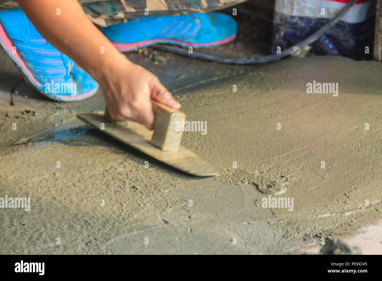 Mason worker use trowel to smooth or leveling liquid concrete of ...