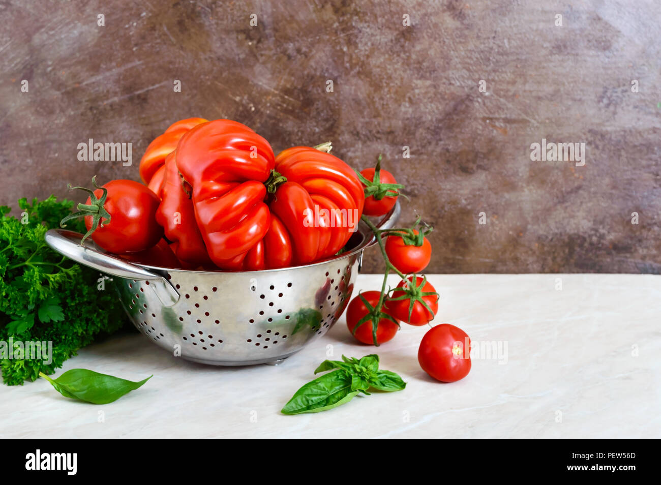 Ripe juicy tomatoes of different varieties, green fragrant basil on the ...