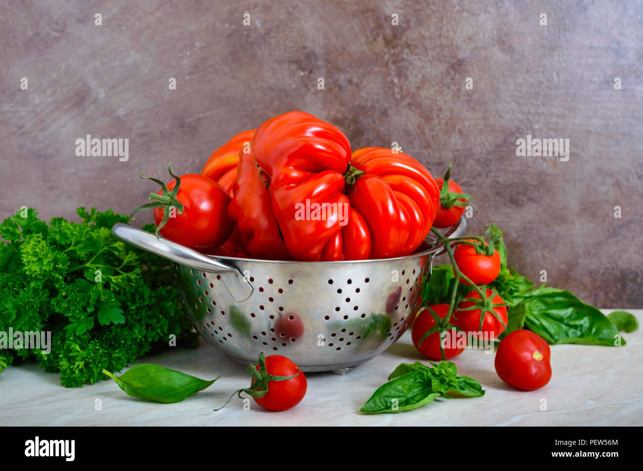 Ripe juicy tomatoes of different varieties, green fragrant basil on the ...