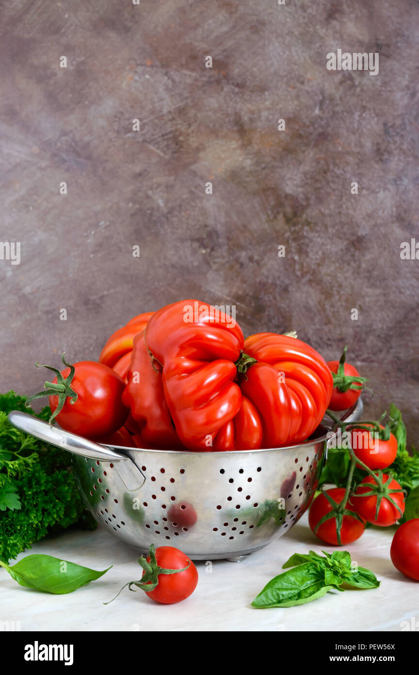 Ripe juicy tomatoes of different varieties, green fragrant basil on the ...