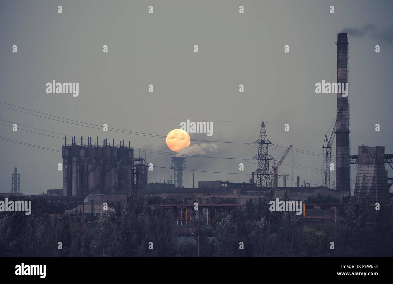 Panorama of full moon rising over industrial landscape Stock Photo - Alamy
