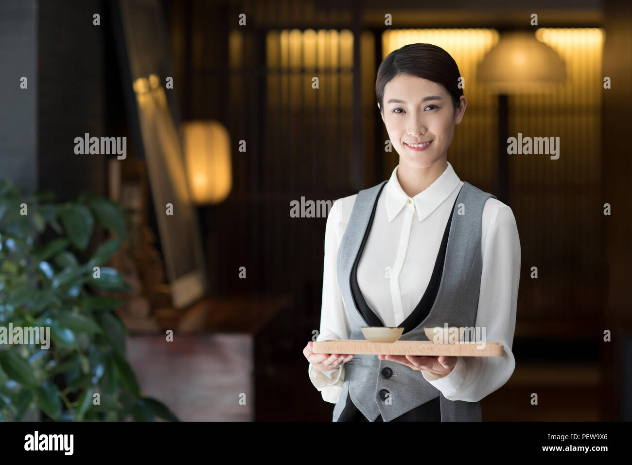 Elegance waitress holding two cups of tea Stock Photo - Alamy