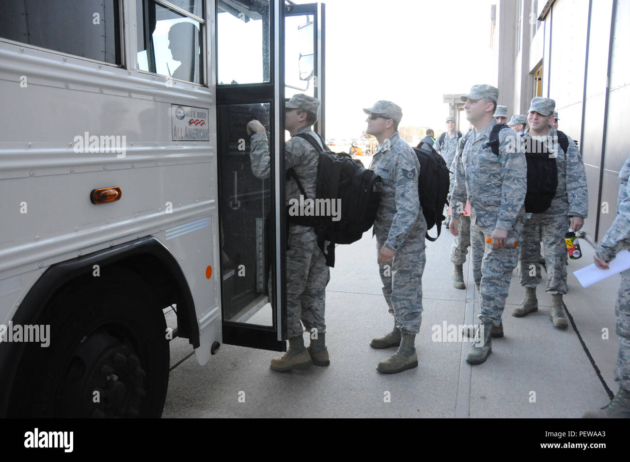 Airmen assigned to the 134th Air Control Squadron climb aboard buses ...