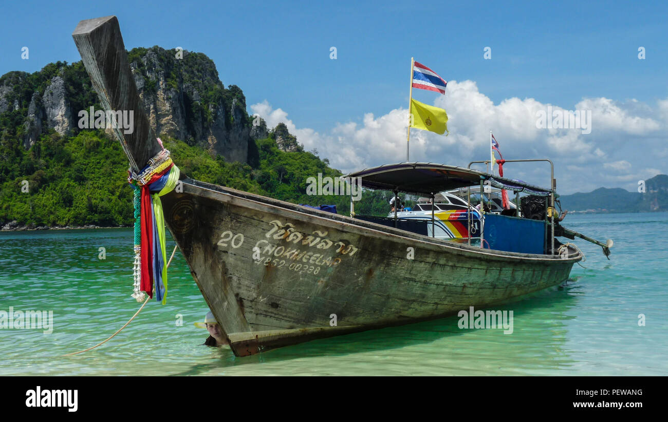 Landscape view of a traditional long-tail boat with Thai flags waiting ...