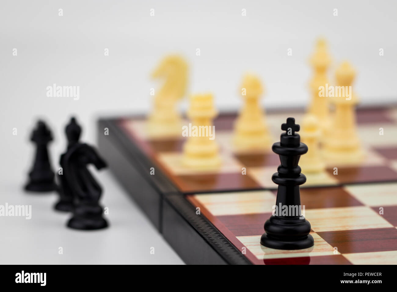 King chess piece with chess figures standing on white table in a ...