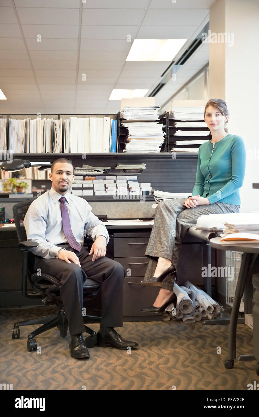 Portrait of a young Black businessman and Caucasian businesswoman in an office cubicle Stock ...