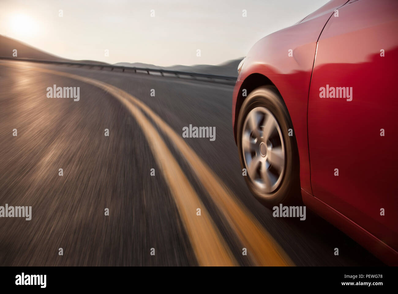 Low angle side view of a car and a tire moving on the road Stock Photo ...