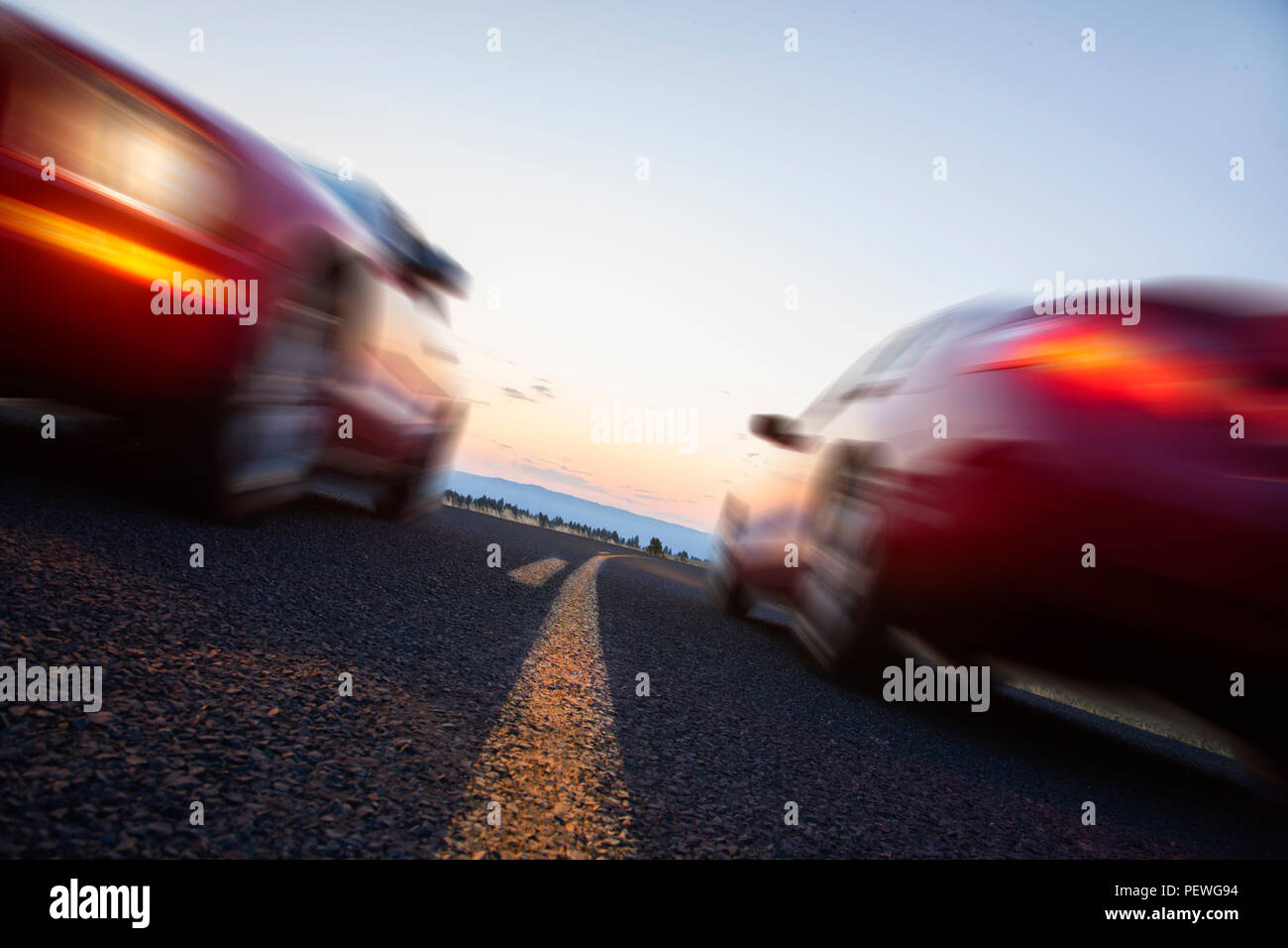 A low angle view of two cars blurred and passing each other going ...