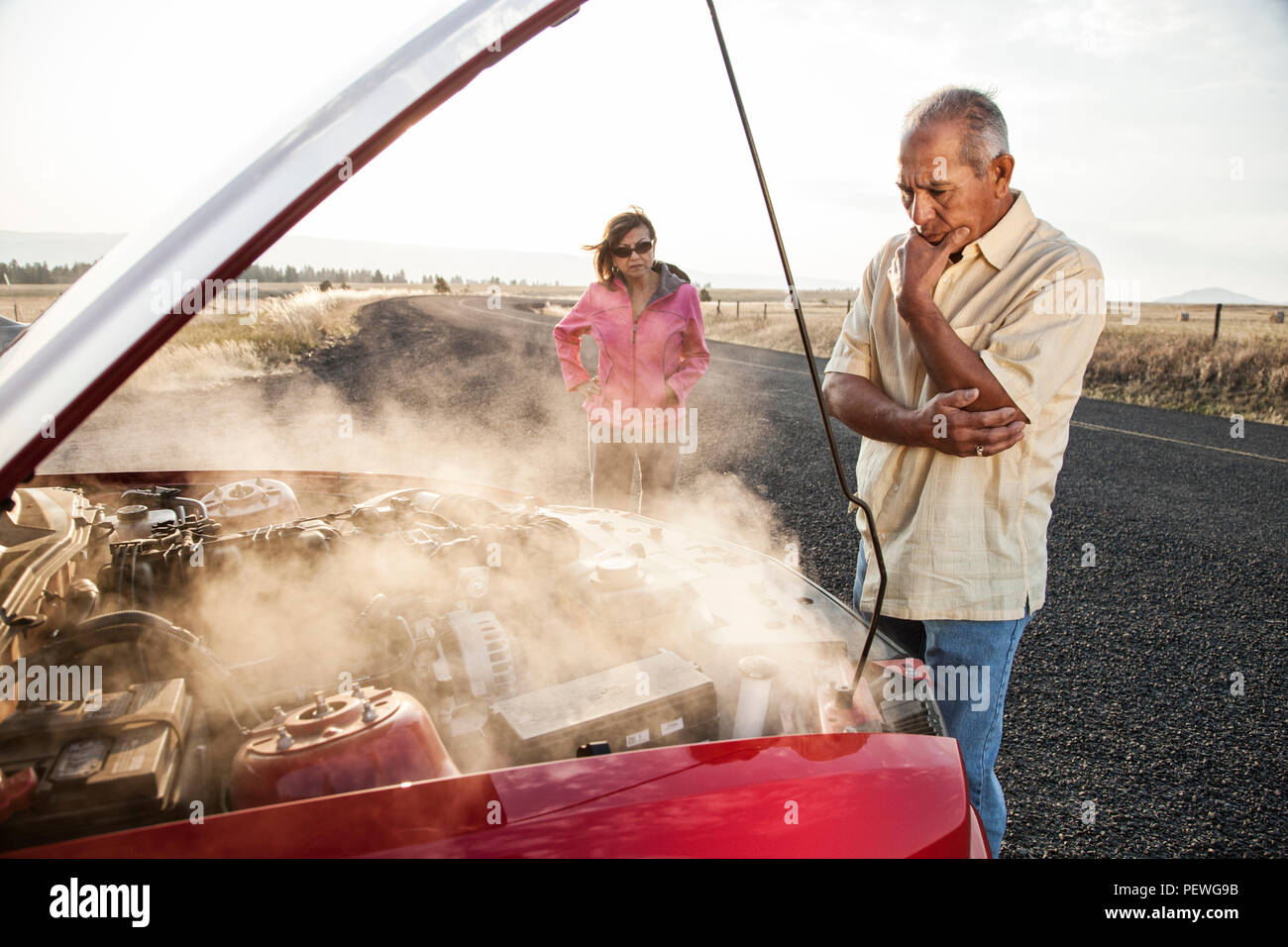 An Hispanic senior couple pulled over at the side of the road with ...
