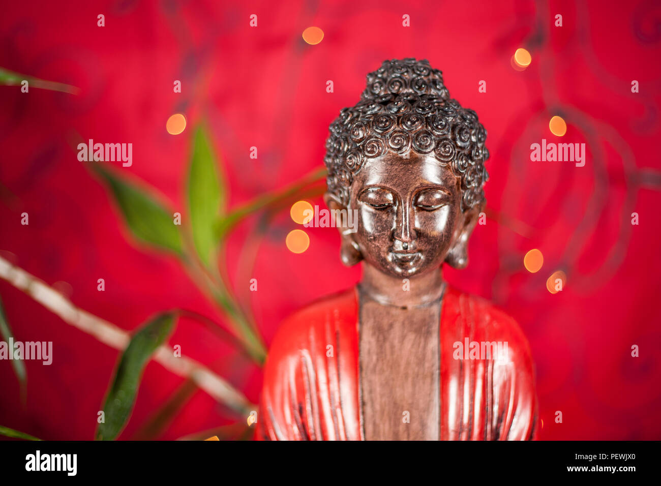 Red zen buddha statue meditating with beautiful meditative blurred ...