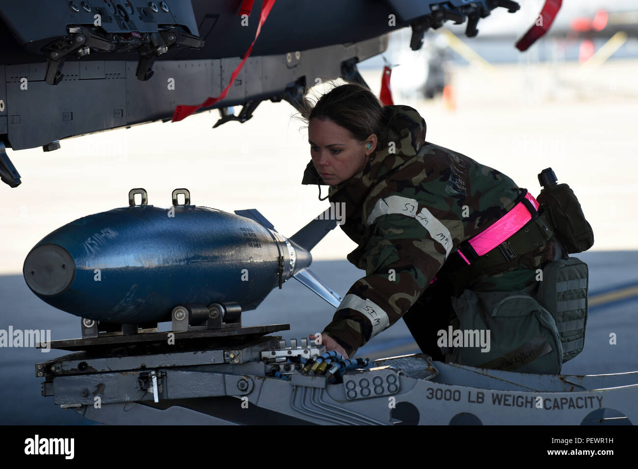 Tech. Sgt. Danielle Lynch, 4th Maintenance Group squadron lead crew, loads a simulated bomb onto ...