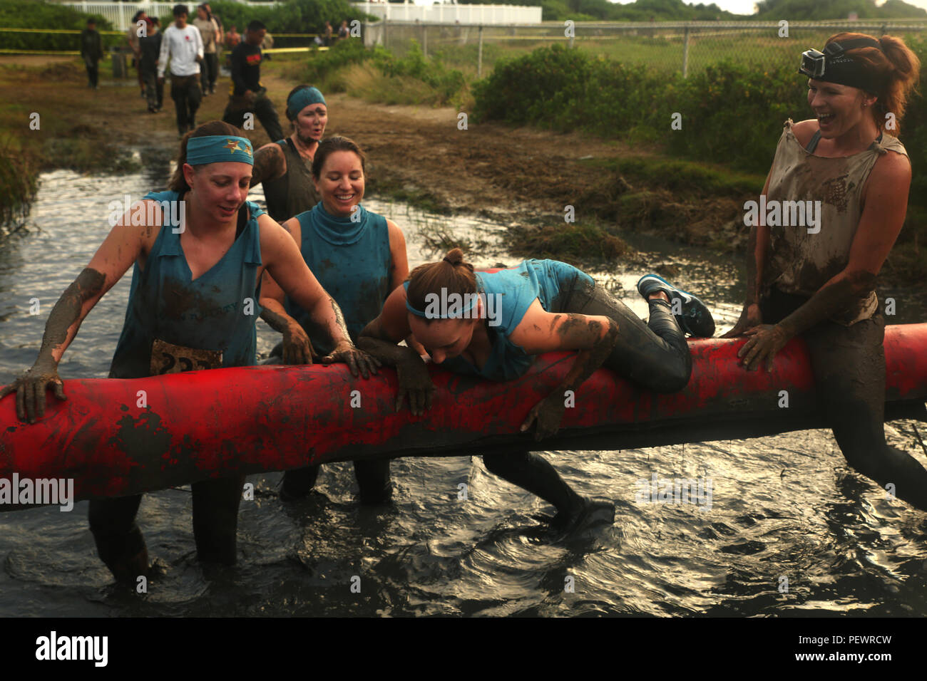 Team “Keep Calm and Mud On” climbs over one of the 16 obstacles aboard ...