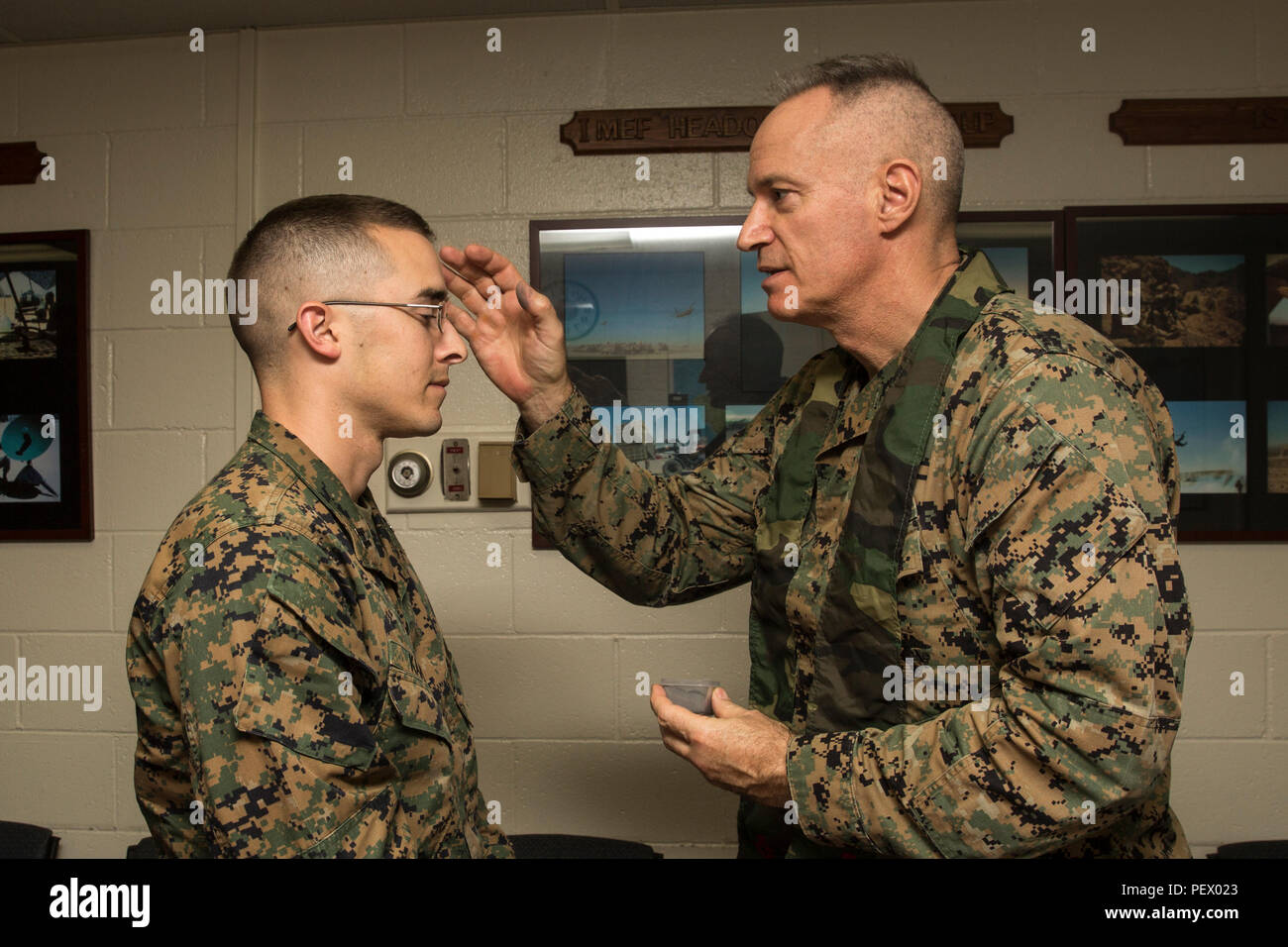 Commander James Johnson, right, marks Capt. Christopher Karle with ash ...
