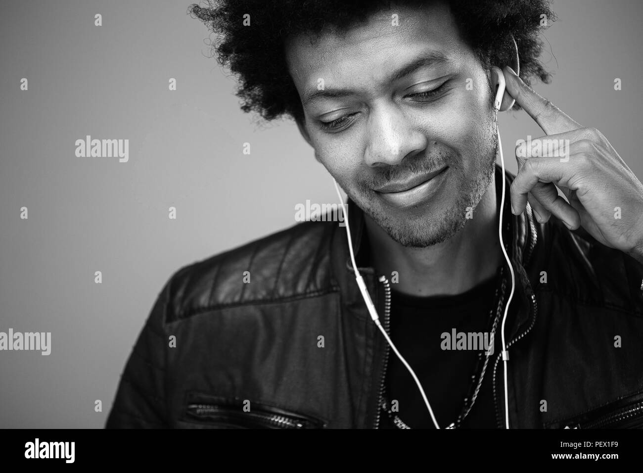 Happy african man smiling listening to music in headphones. White background Stock Photo - Alamy