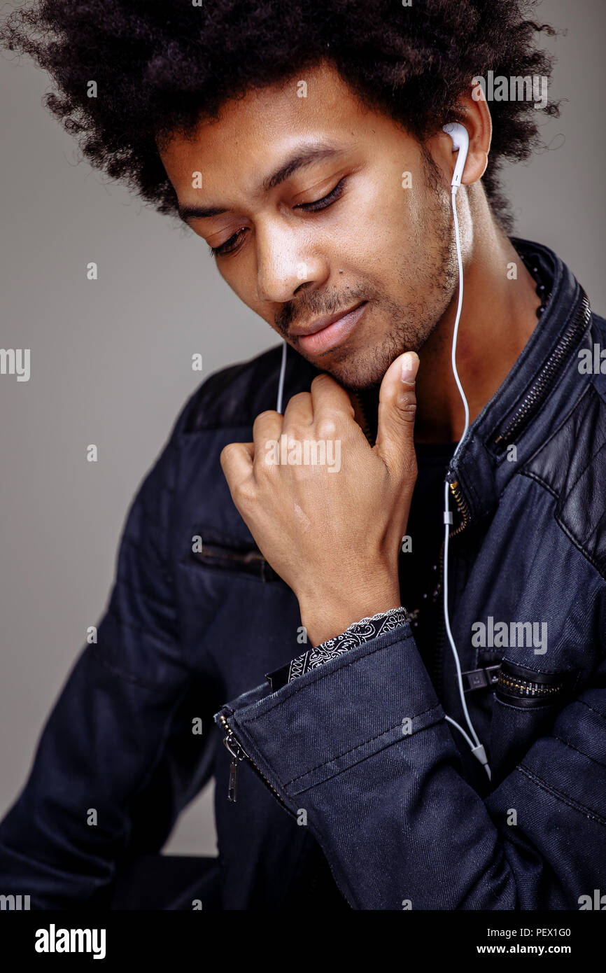 Happy african man smiling listening to music in headphones. White ...