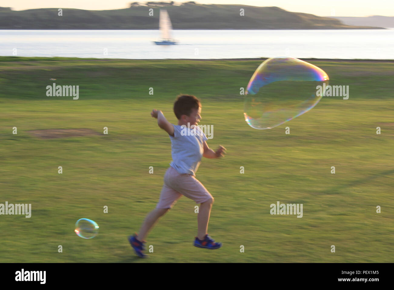 Boy chasing bubbles hi-res stock photography and images - Alamy