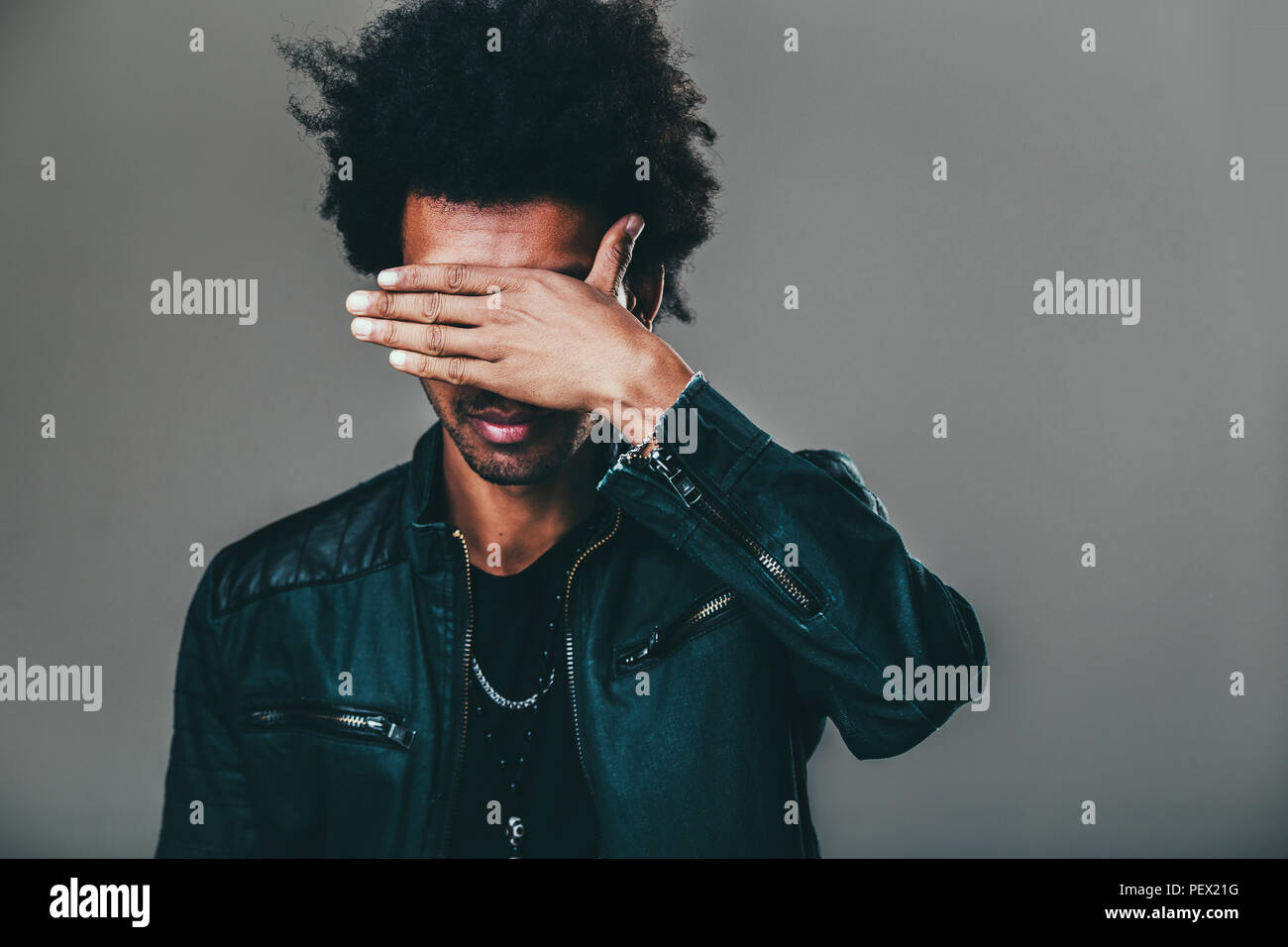 Unrecognizable unshaven African American man with tousled hair making ...