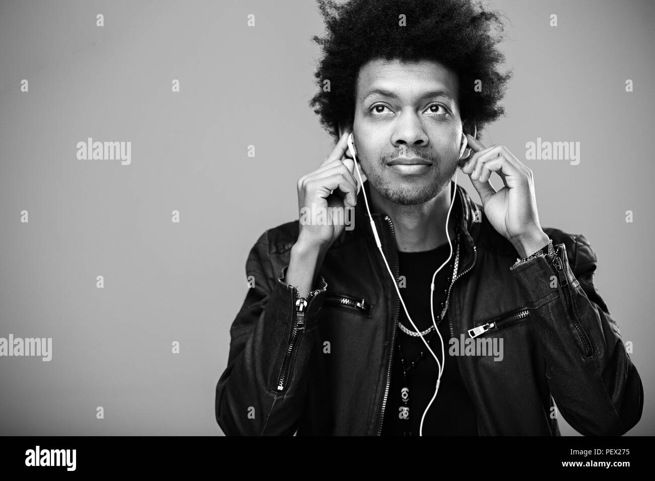 Happy african man smiling listening to music in headphones. White ...
