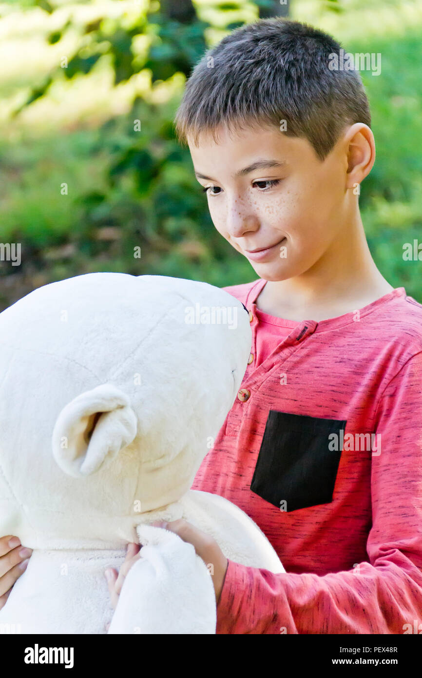 Teenager boy in pink with big white bear Stock Photo - Alamy