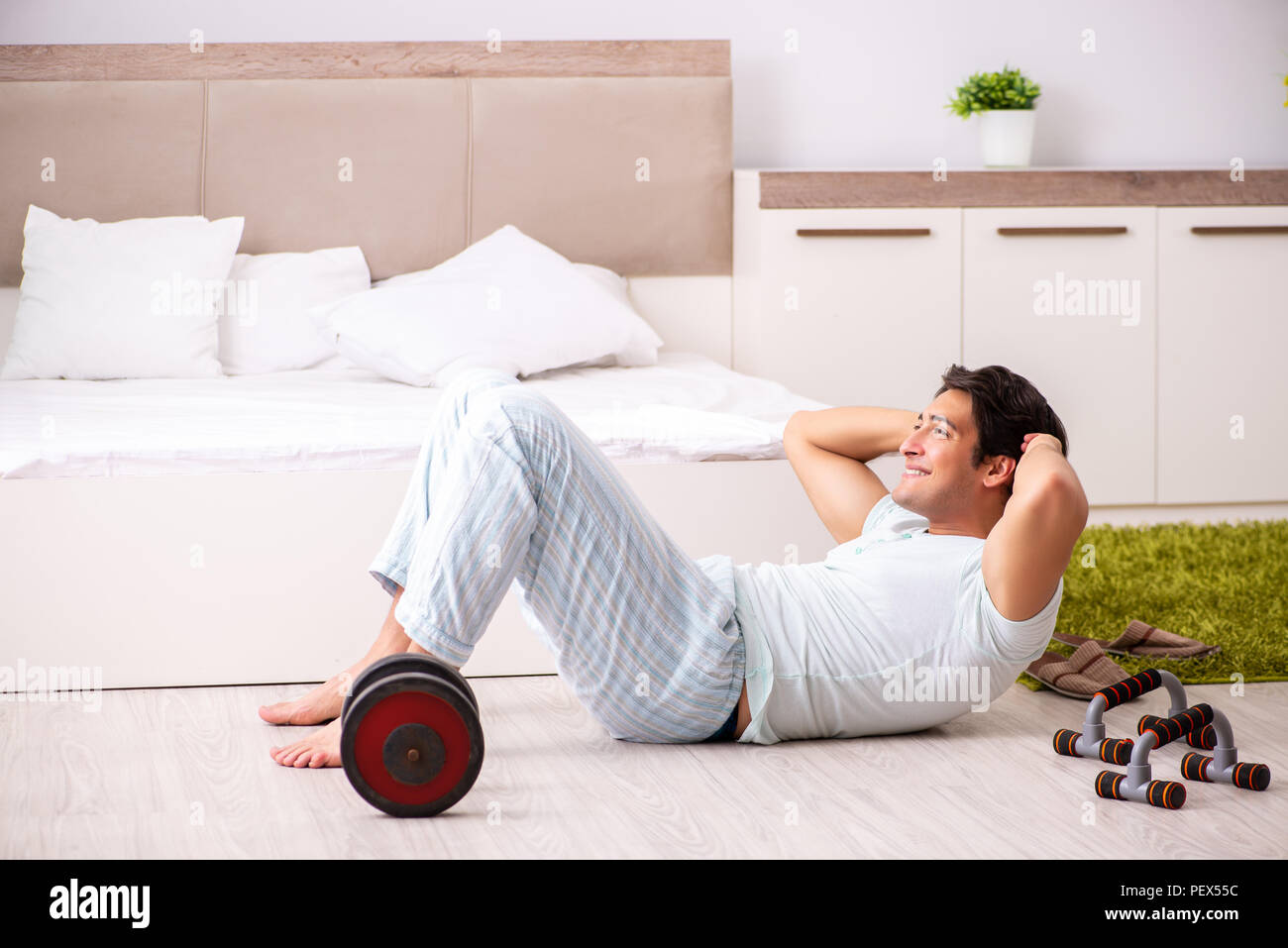Young man doing morning routine in bedroom Stock Photo - Alamy