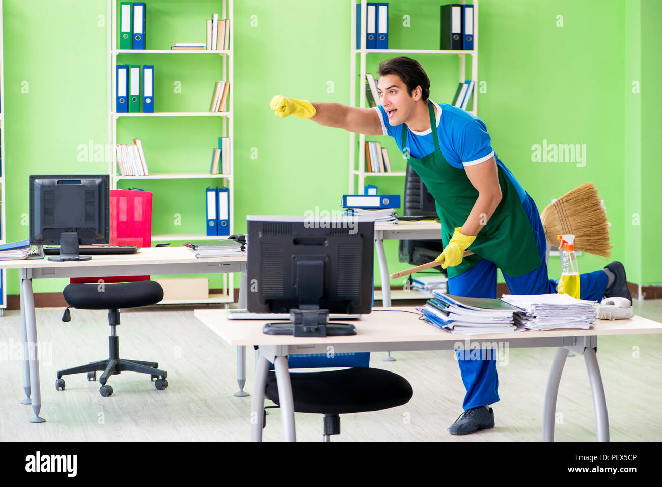 Young male handsome professional cleaner cleaning floor with broom ...
